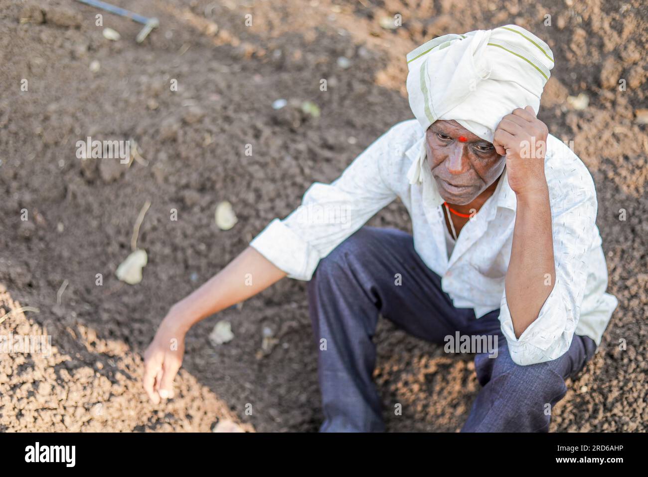 sad farmer, Elderly farmer man sitting in the soil & lost in thought ...