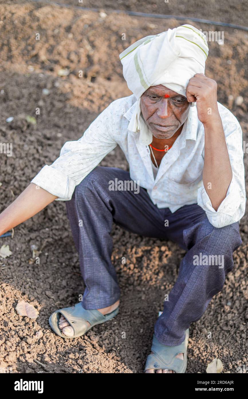 sad farmer, Elderly farmer man sitting in the soil & lost in thought ...