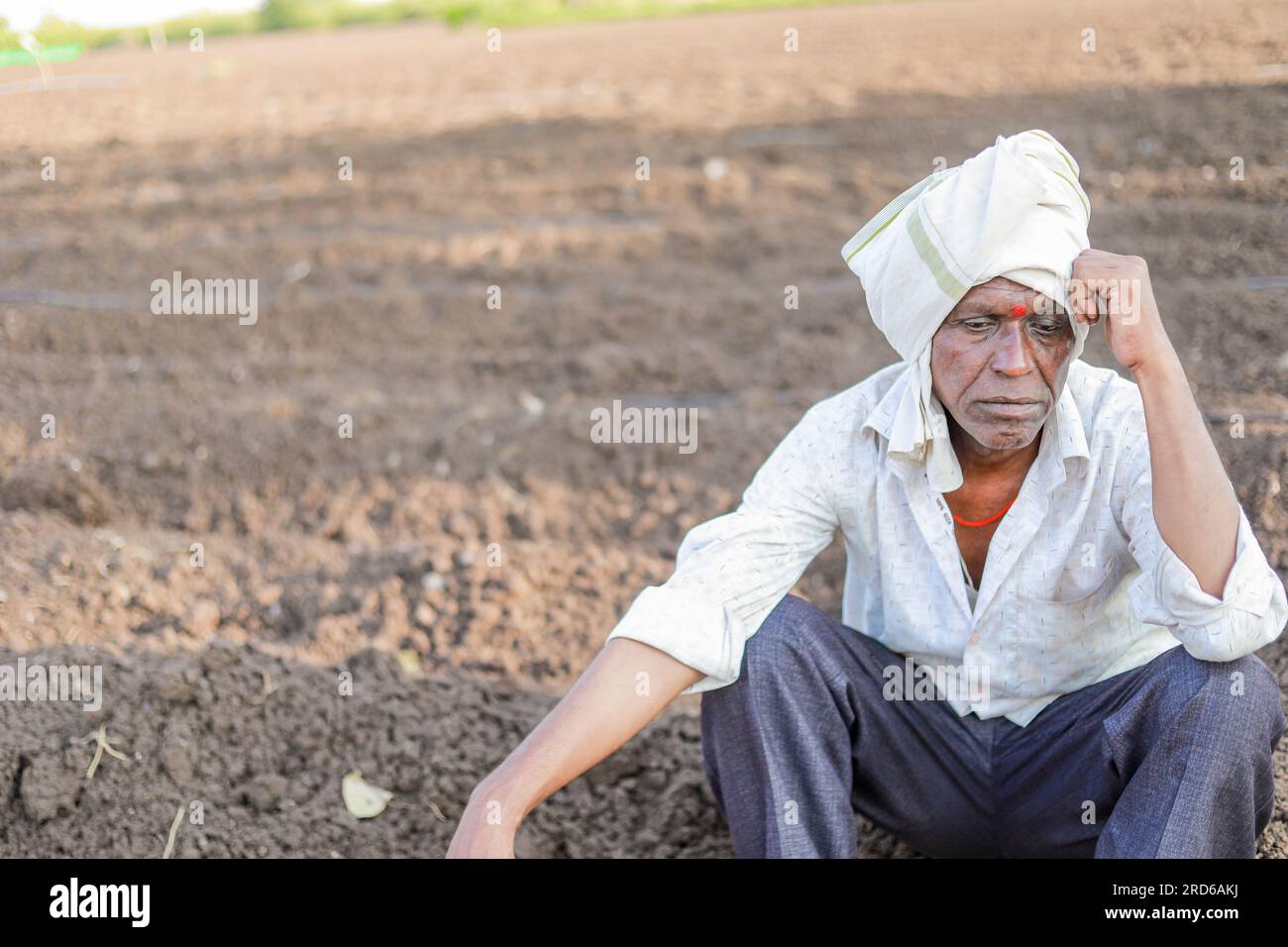 sad farmer, Elderly farmer man sitting in the soil & lost in thought ...