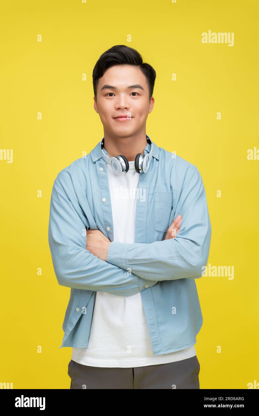 Smiling young man with headphones around neck Stock Photo - Alamy