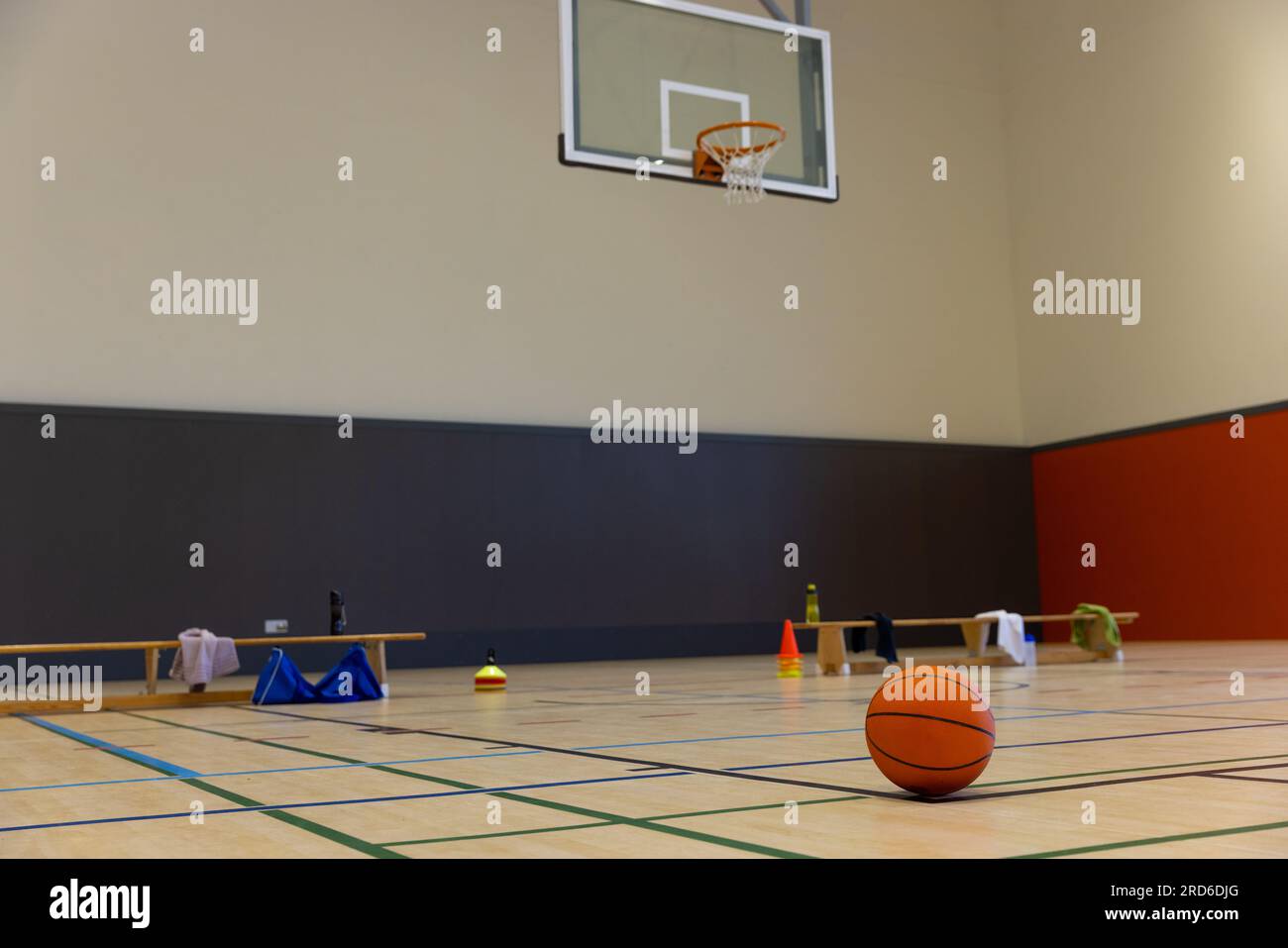 Single basketball lying on basketball court with sports clothes and ...