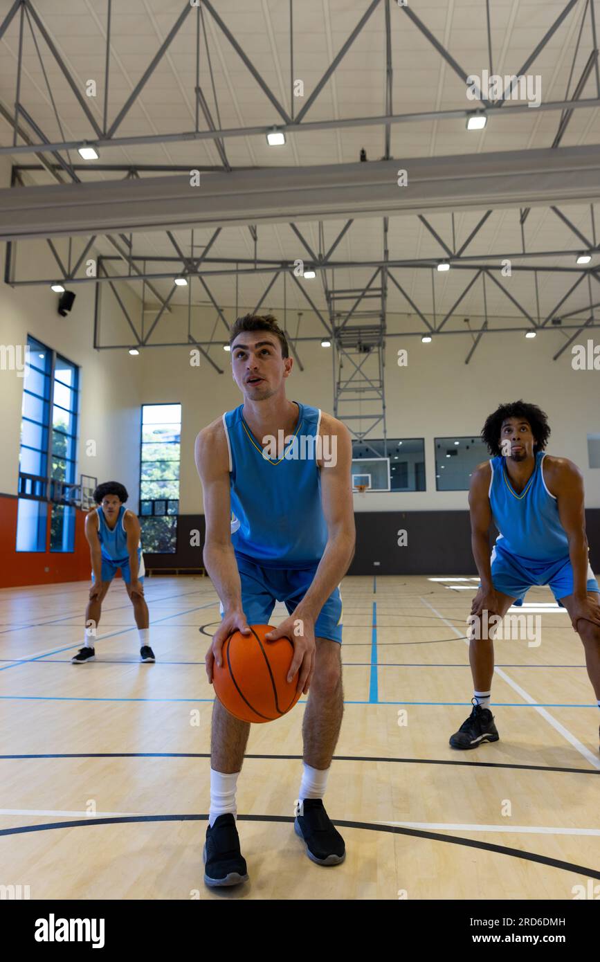 Diverse male basketball players wearing blue sports clothes and ...