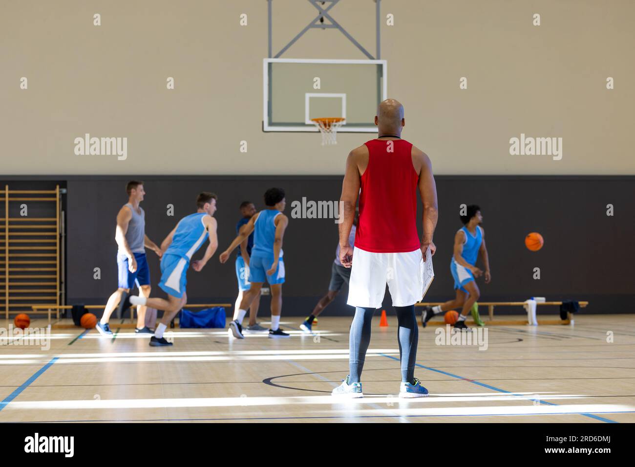 Diverse male basketball players wearing blue sports clothes and playing ...