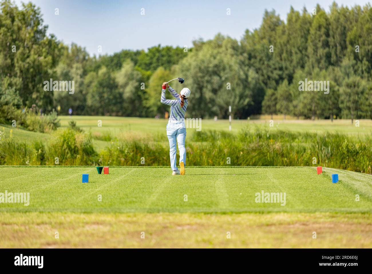 Professional woman golfer wearing sport wear teeing golf in golf ...