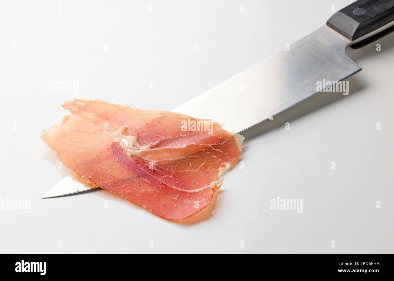 sliced spanish iberico ham and knife on white background Stock Photo ...
