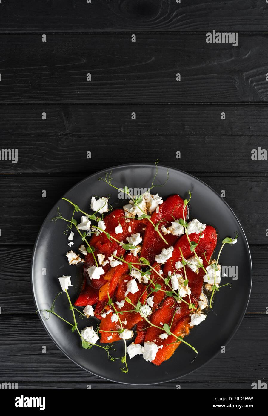 Fried baked red peppers on a plate with feta cheese, top view, vertical ...