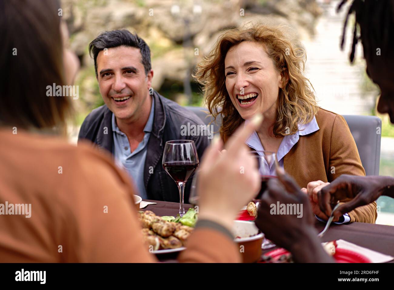A group of friends, including a smiling blonde woman and a man, enjoy a ...