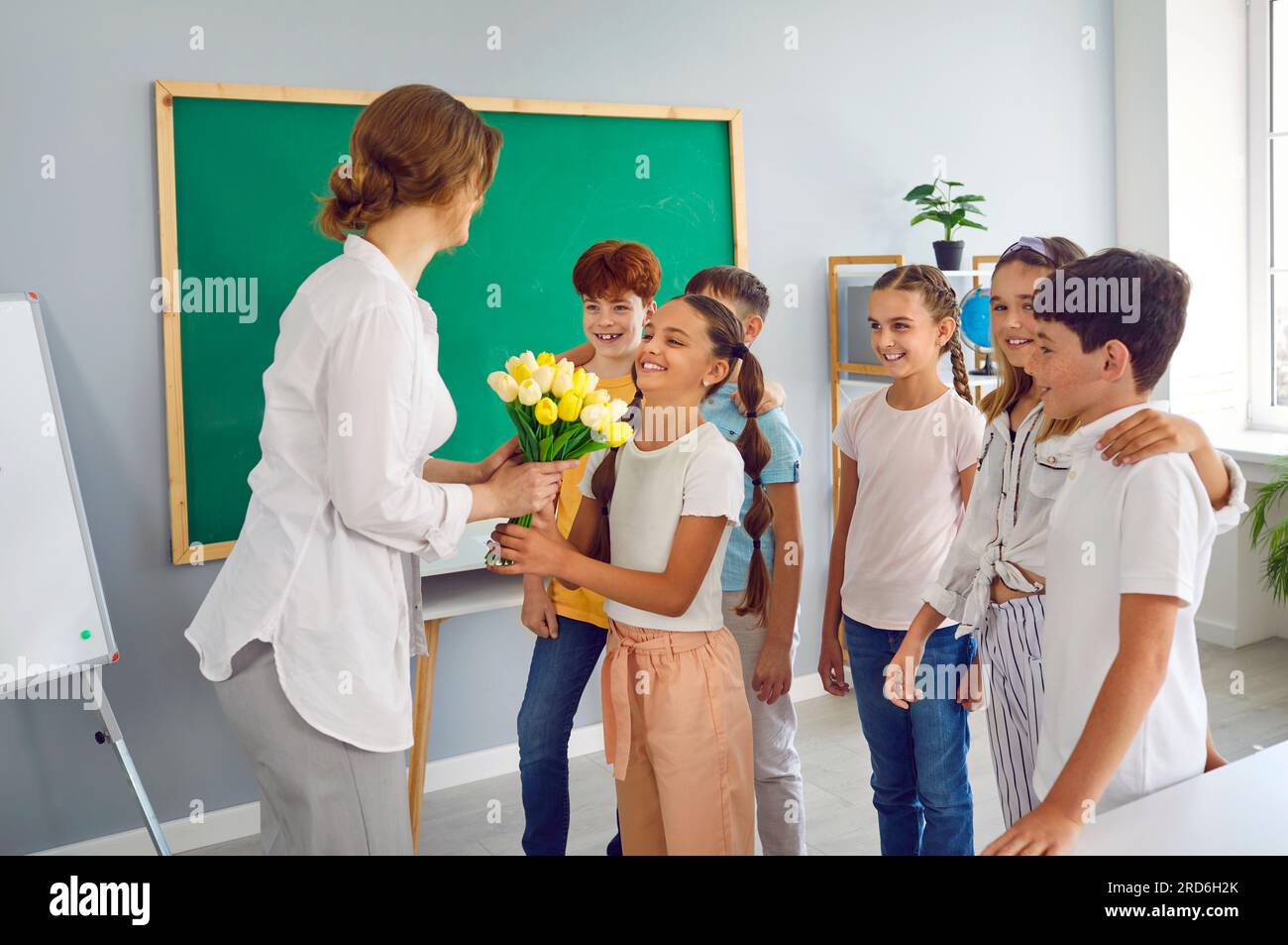 Teacher's Day. Elementary school children give the teacher a bouquet of ...