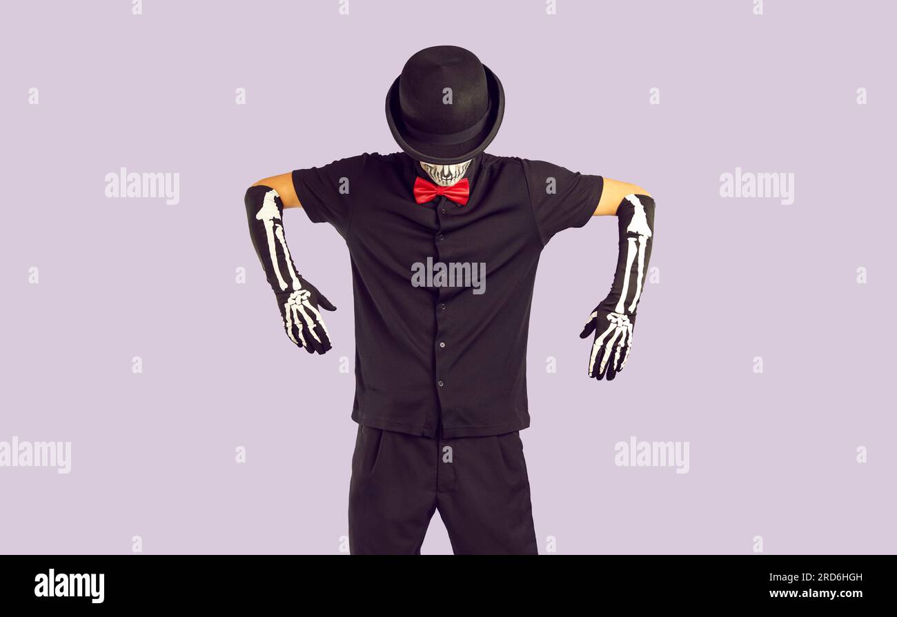 Guy in spooky skeleton Halloween costume standing isolated on light ...