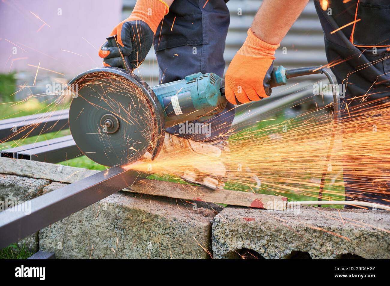 Worker cutting metal pole with grinder. Grinding machine. Partial image ...