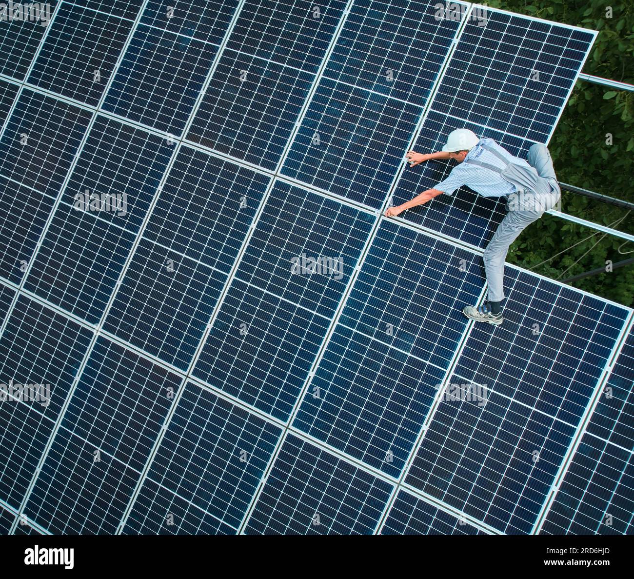 Top view of man technician in safety helmet installing photovoltaic ...