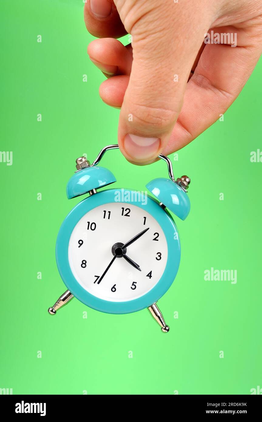 hand holding old style alarm clock, close up Stock Photo - Alamy