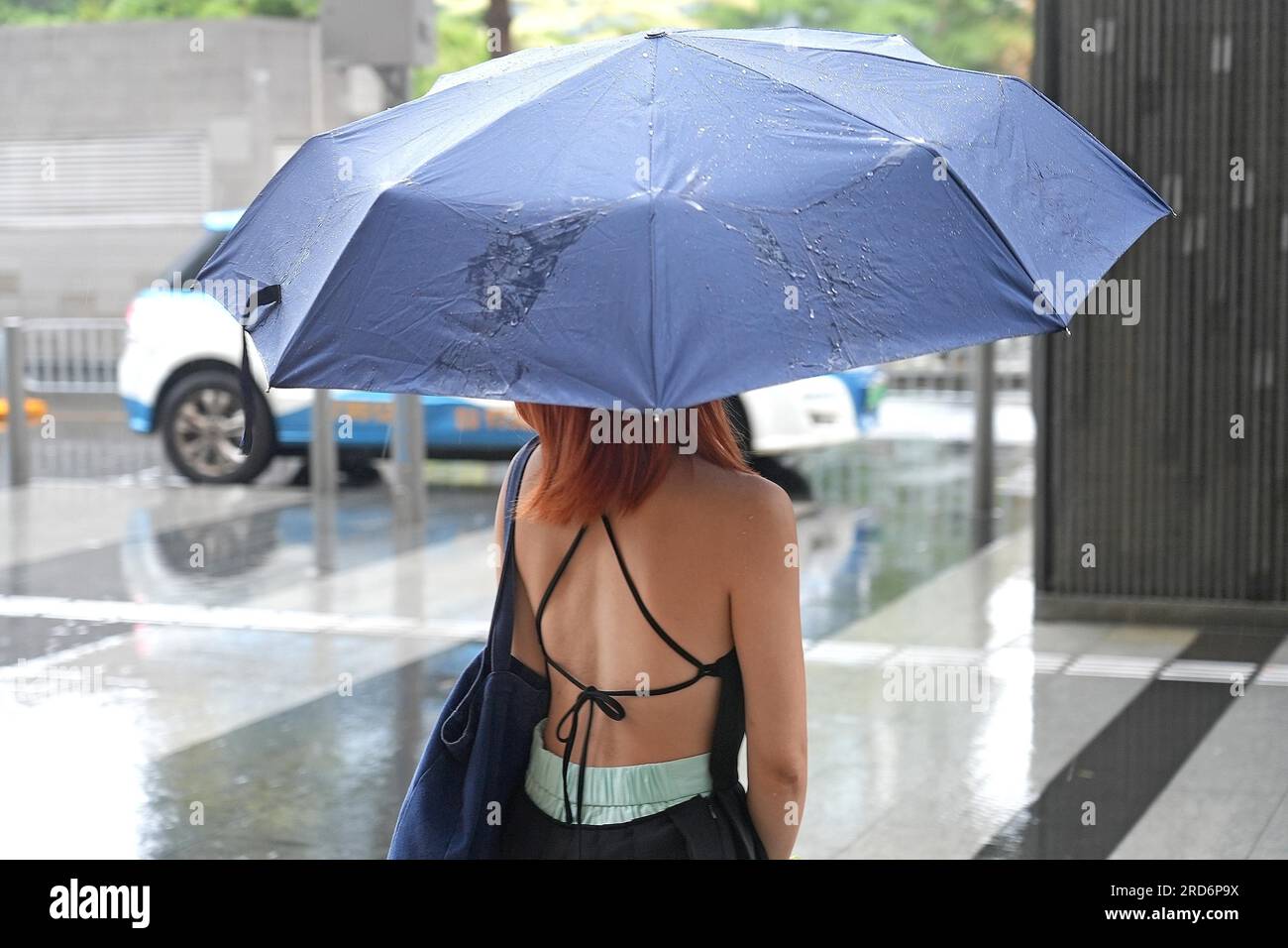 Local residents travel out in rain and wind as typhoon Talim approaches in Shenzhen City, south ...