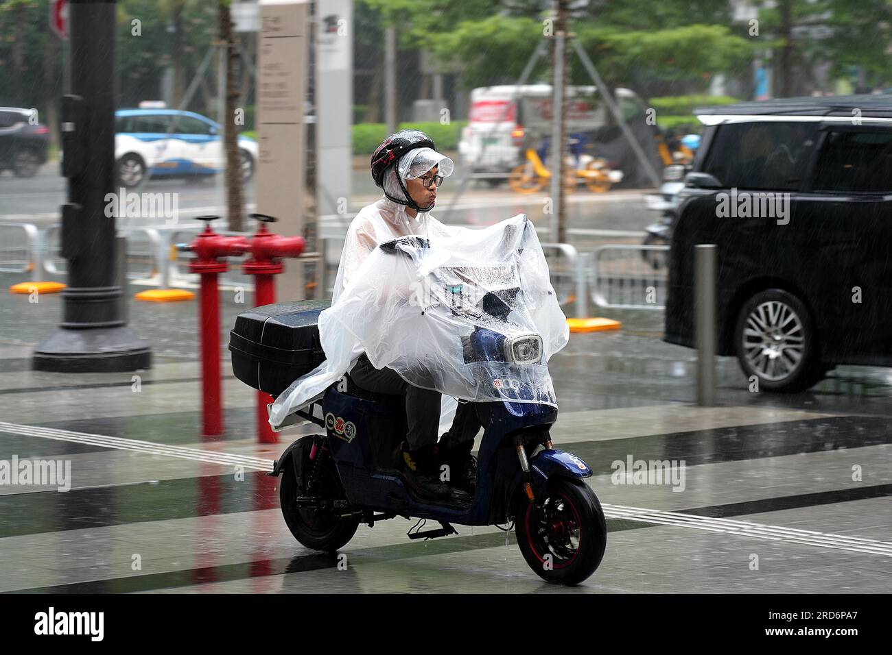 Local residents travel out in rain and wind as typhoon Talim approaches ...