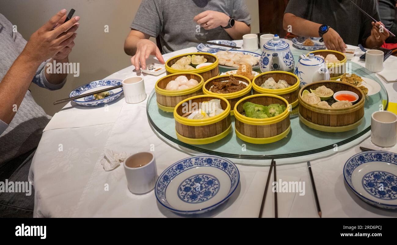 People taking photos of a table full of Yumcha dishes using smart phone ...