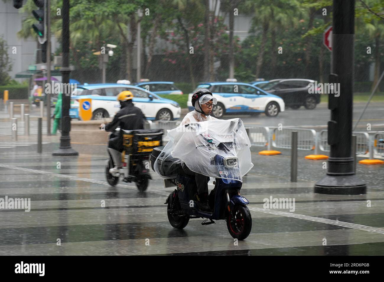 Local residents travel out in rain and wind as typhoon Talim approaches ...
