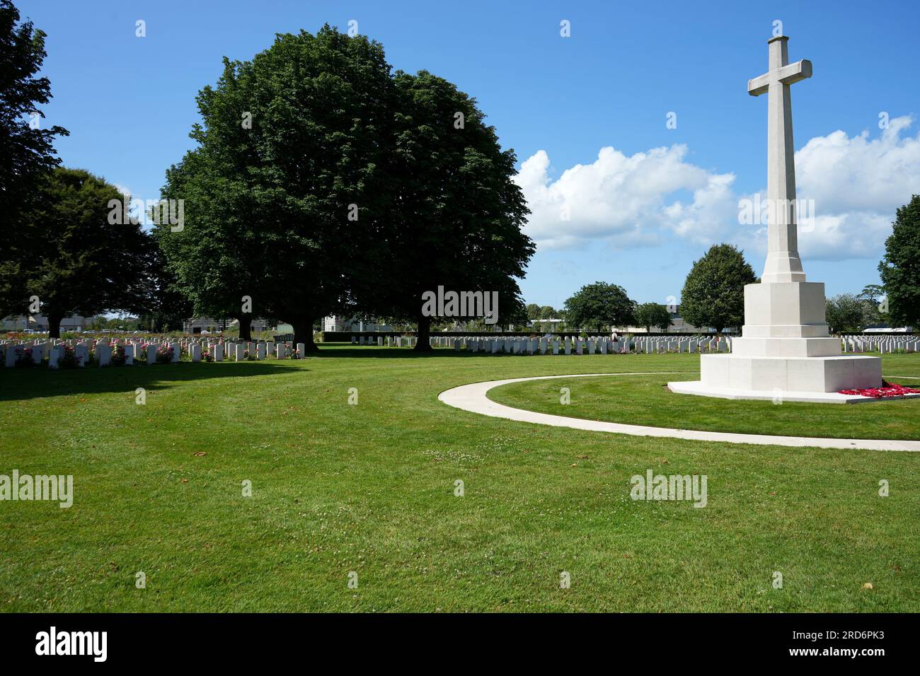 Memorial Cross with Poppy wreaths in the sunlight at The Bayeux war ...