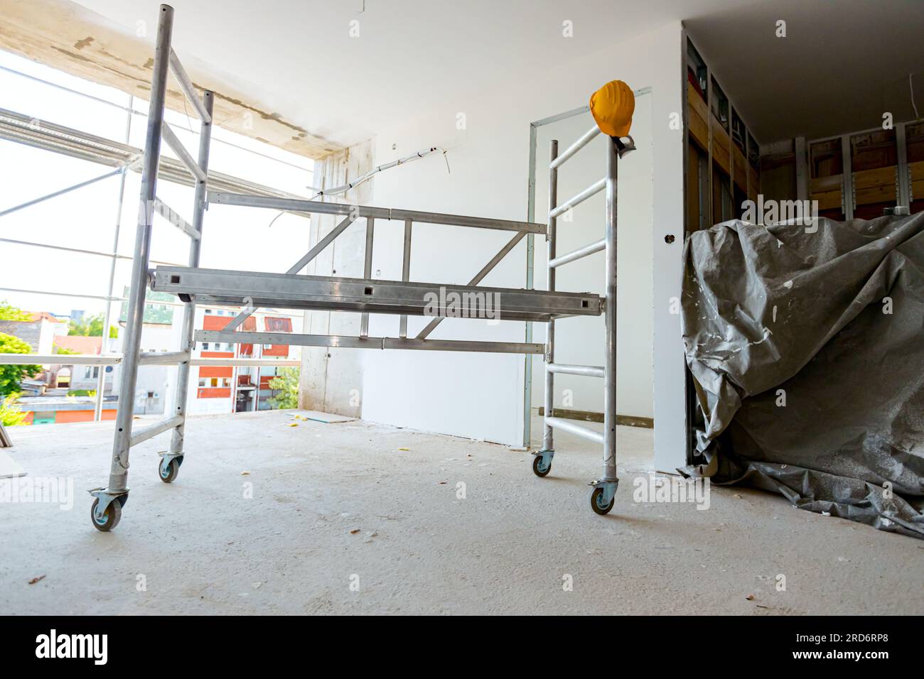 Mobile metal scaffolding with small wheels and protective helmet on it ...