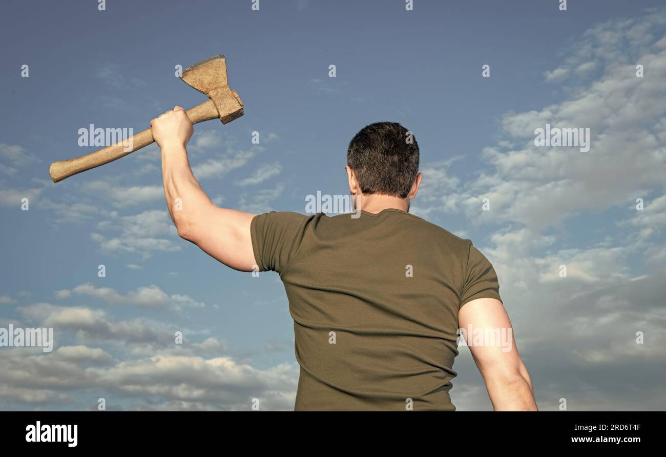 back view of free guy with axe. man hold ax. brutal man on sky ...