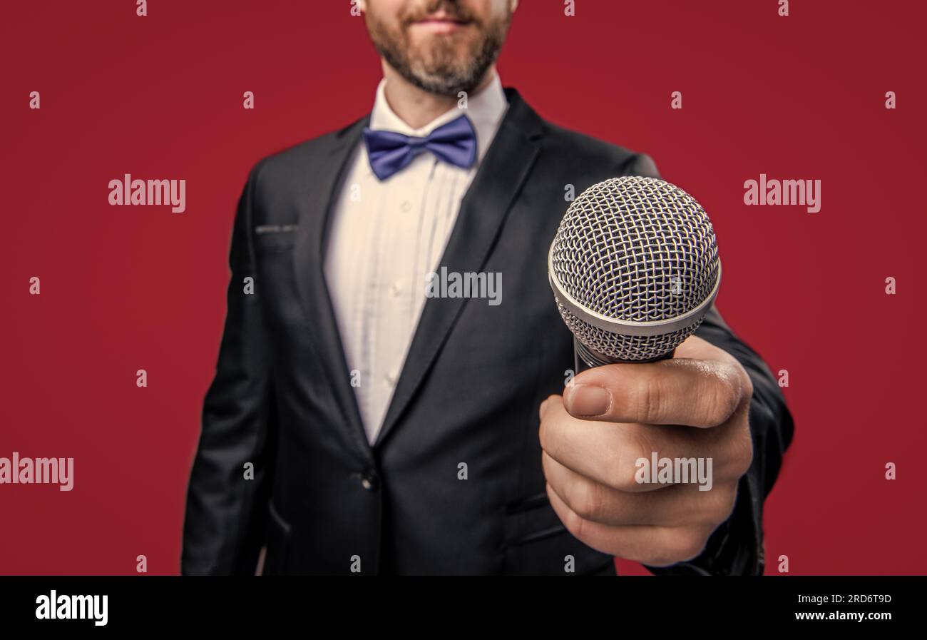 presenter hold microphone isolated on red background. microphone in ...