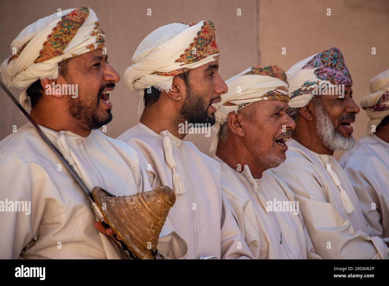 A group of Omani men dressed in traditional clothes perform a dance in ...