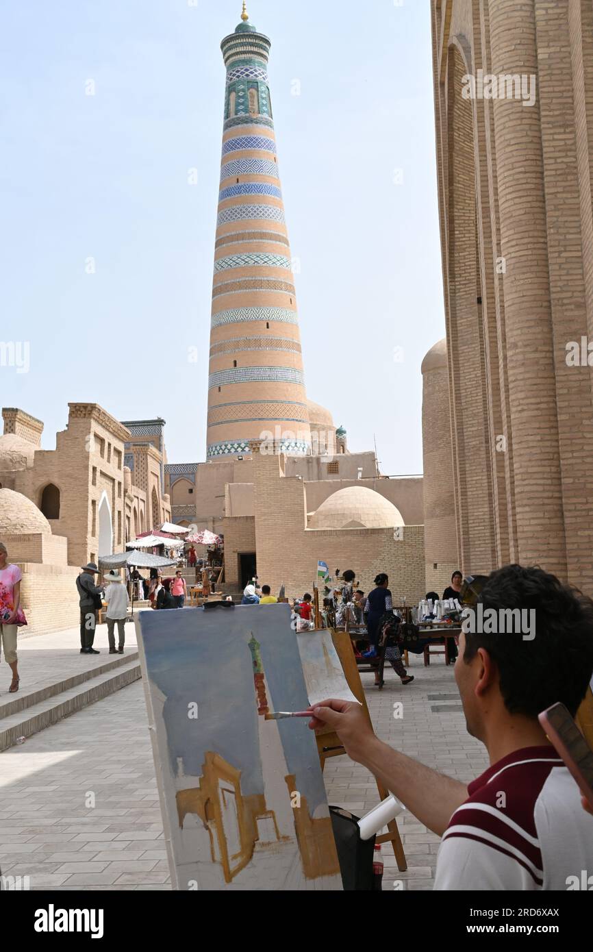 Close up of a uzbek man painting a minaret on a canvas in the city of ...