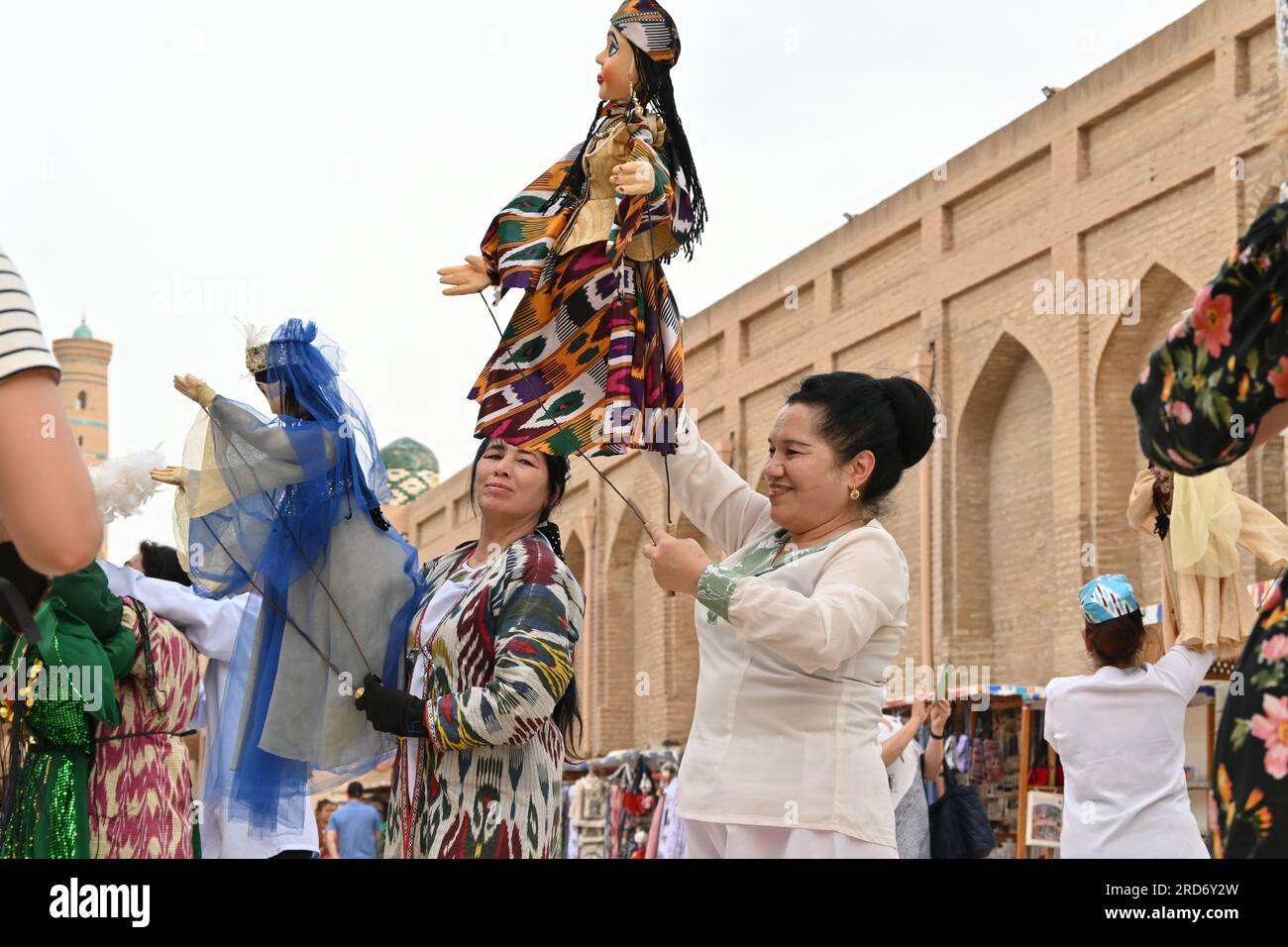 Uzbek woman holding a puppet during a performance on the street in ...