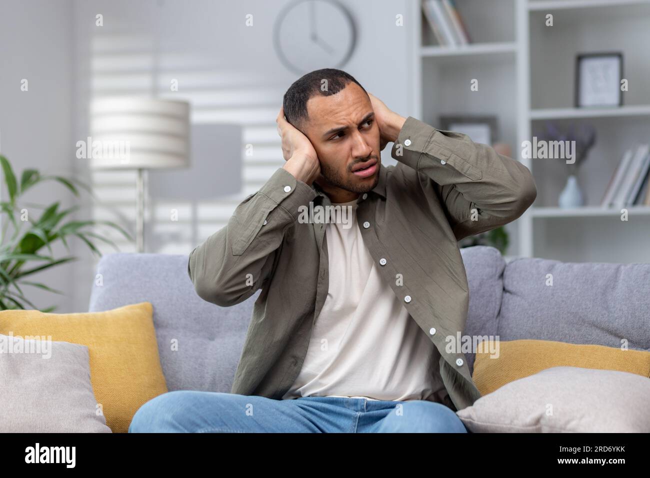Worried and upset young hispanic man scared by loud noise and scream ...