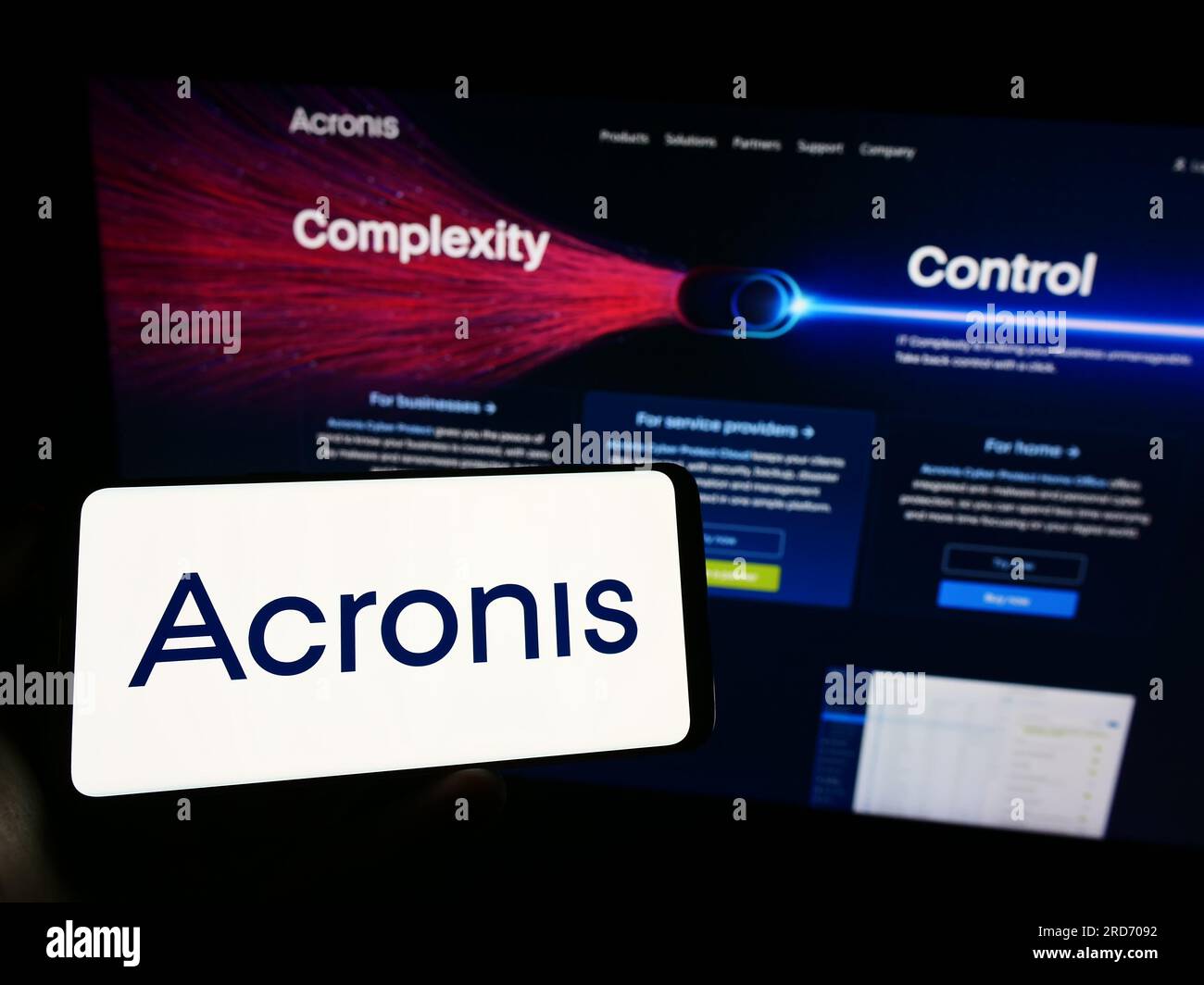 Person holding cellphone with logo of Swiss technology company Acronis ...