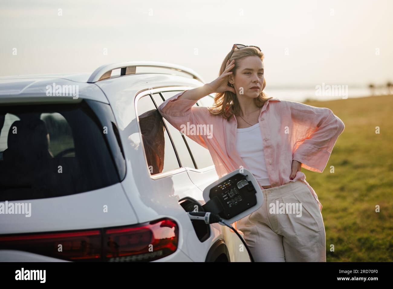 Woman charging her electric car, prepared for charging it sustainable ...