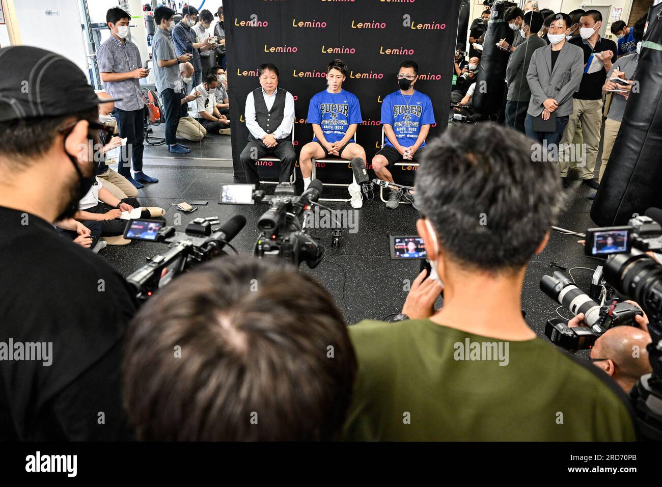 Naoya Inoue of Japan, center, talks to the media with his trainer and ...