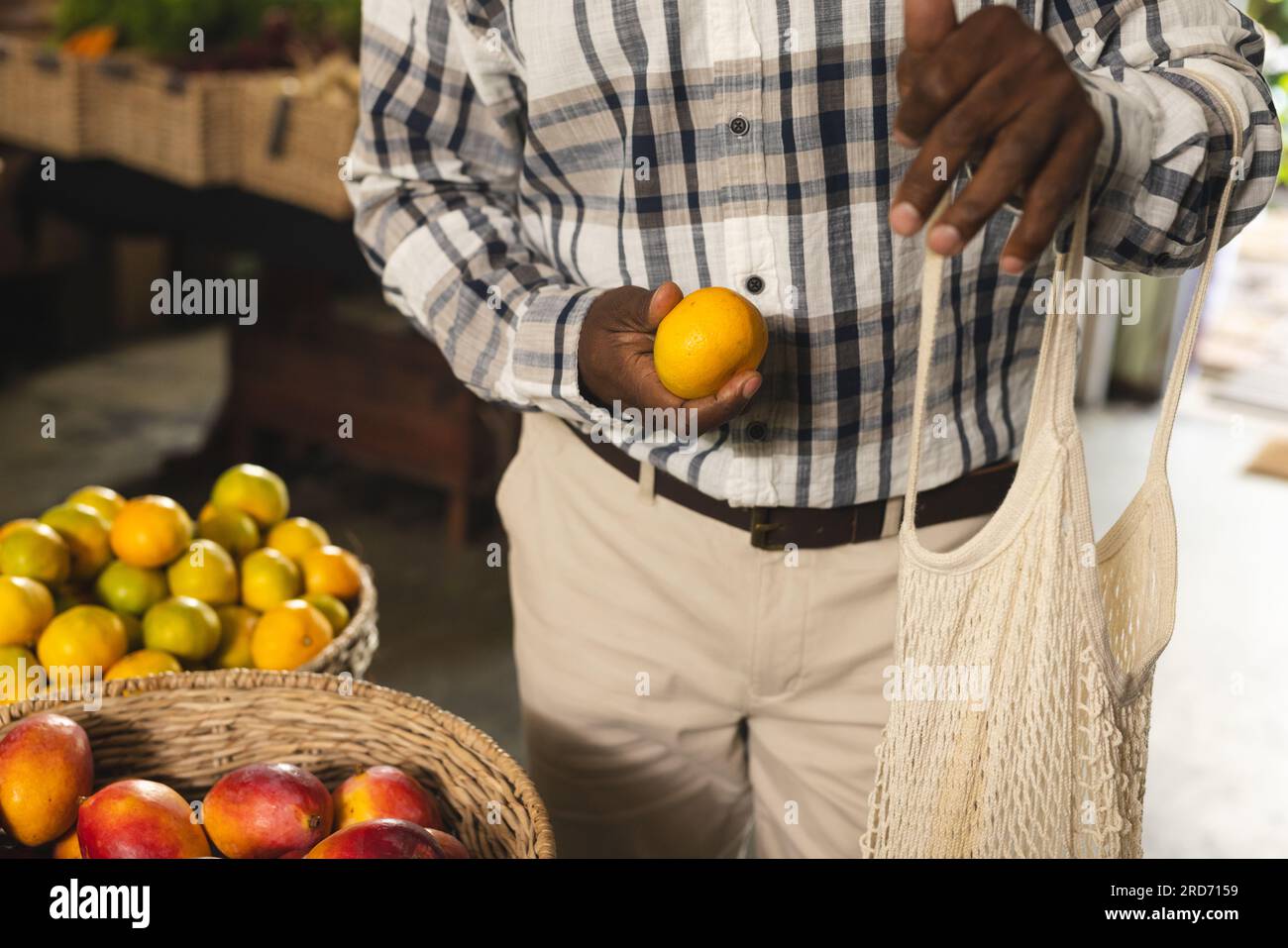Senior african american man holding lemon, shopping at health food ...