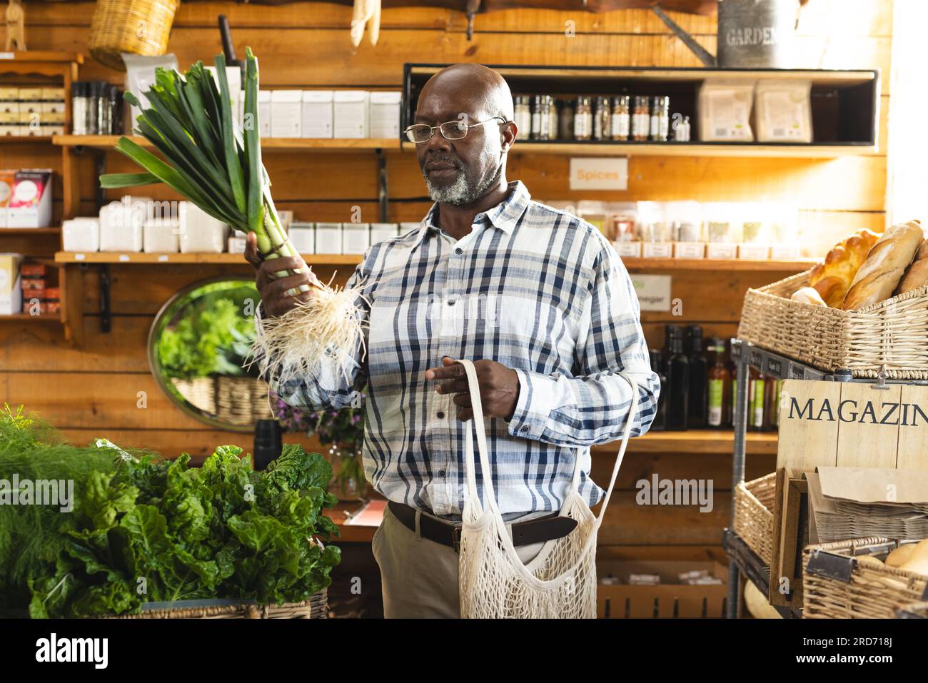 Senior african american man holding leek, shopping at health food ...