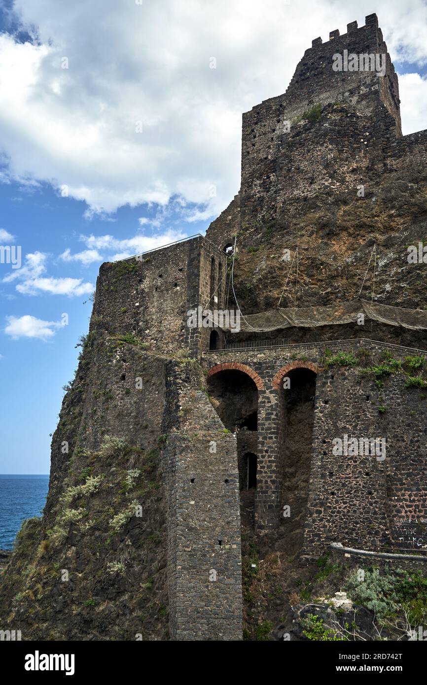 Ruins of a Norman castle on a volcanic cliff in the village of Aci ...