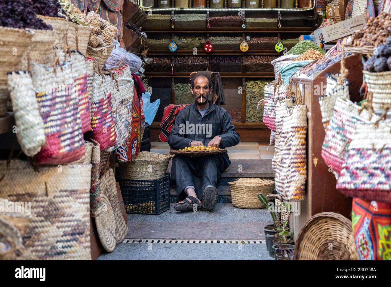 Man gazes into the camera as he sorts through dried fruits and nuts at ...