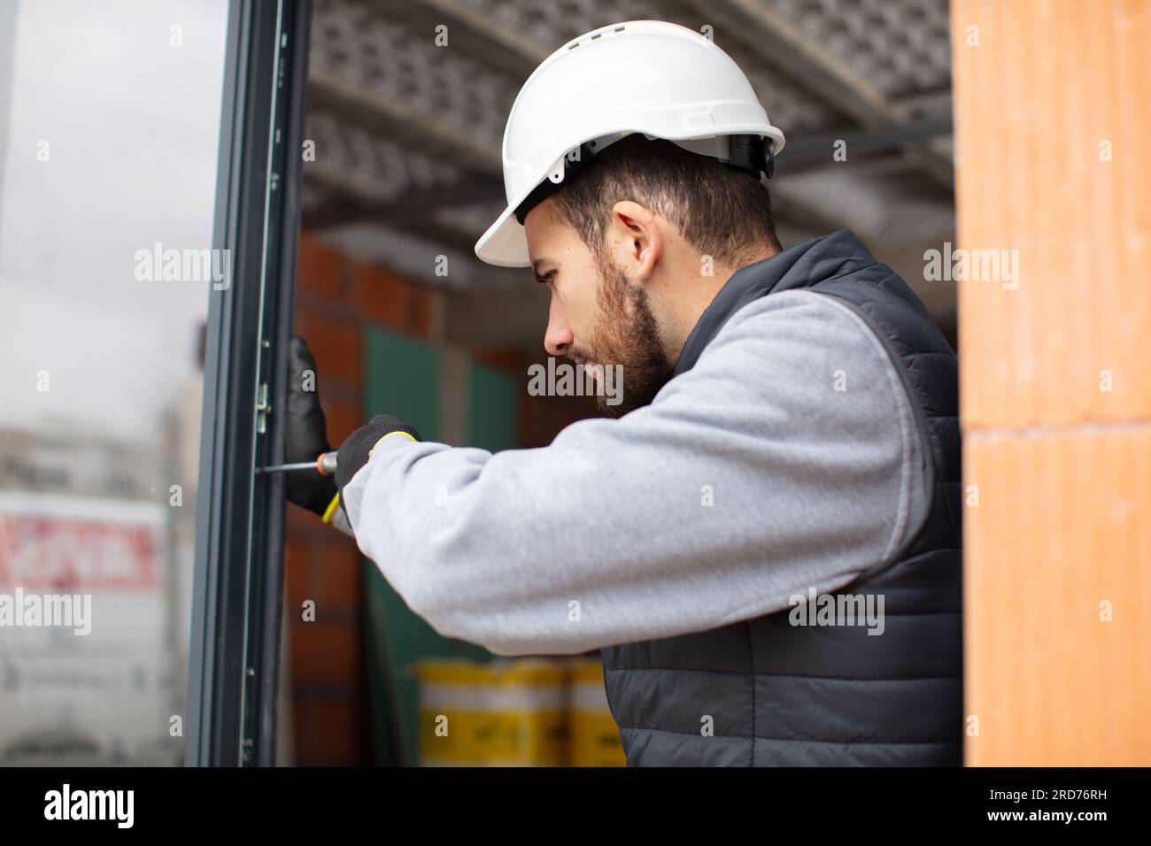 service man installing window with screwdriver Stock Photo - Alamy