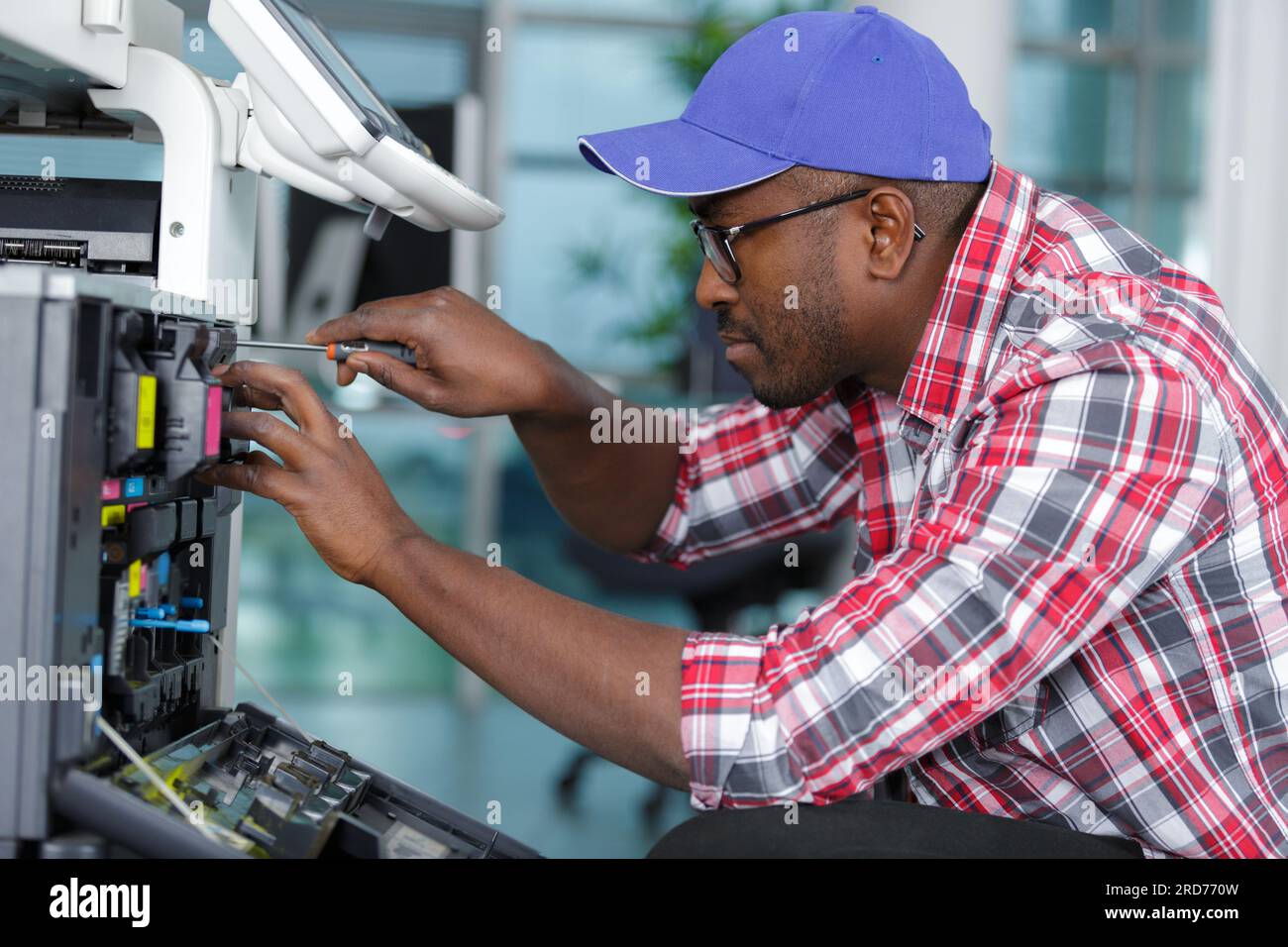 young male technician repairing digital photocopier machine Stock Photo ...