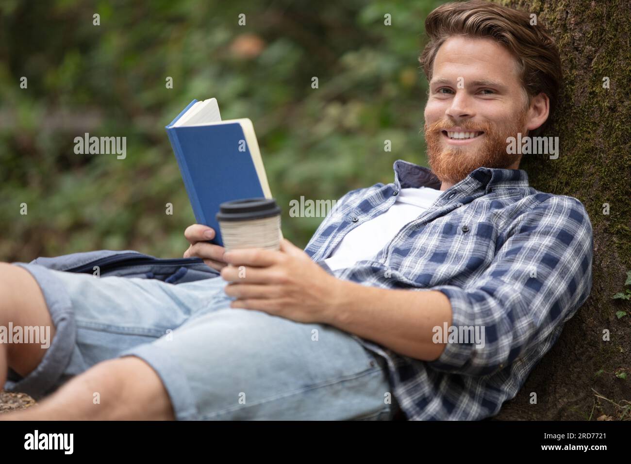 School boy reading under tree hi-res stock photography and images - Alamy