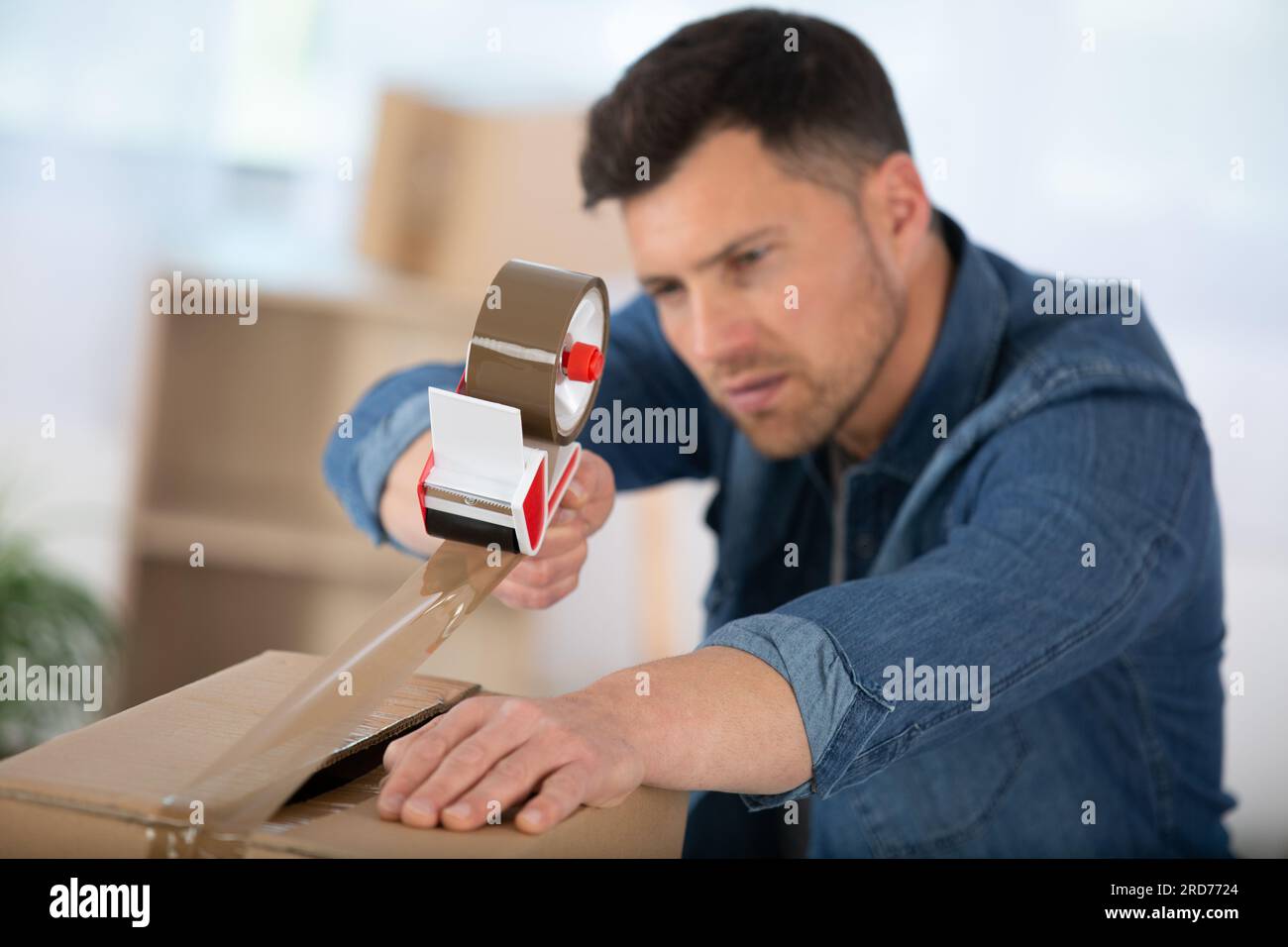 Man taping cardboard box hi-res stock photography and images - Alamy