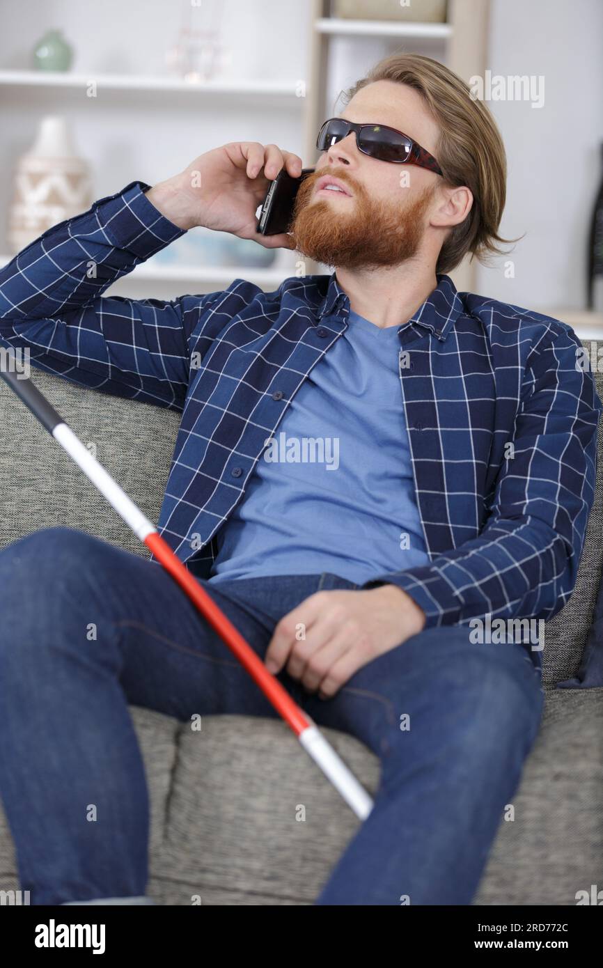 blind man on the phone sitting on sofa at home Stock Photo - Alamy
