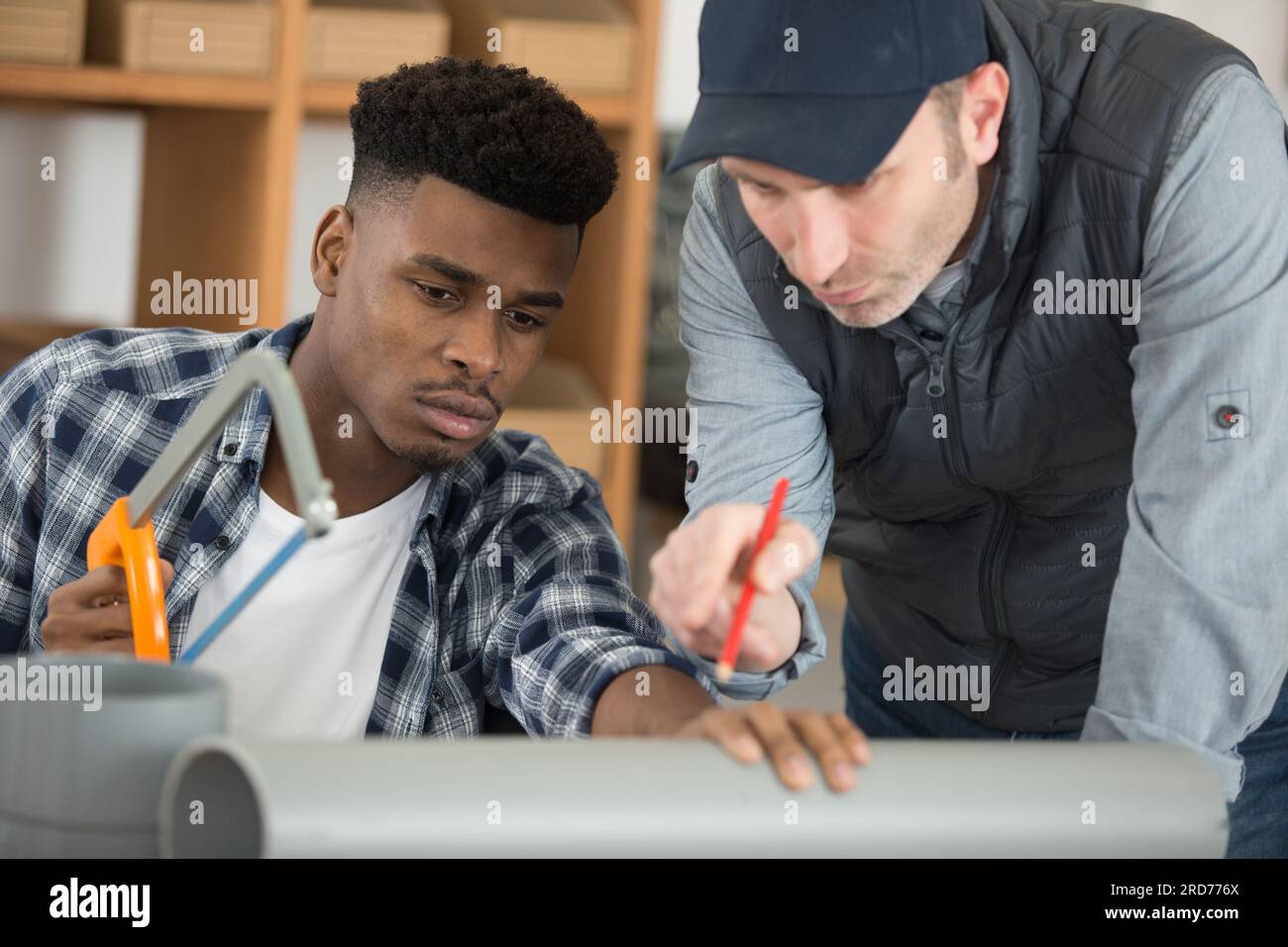 two men of plumbers dealing with pipes in site Stock Photo - Alamy