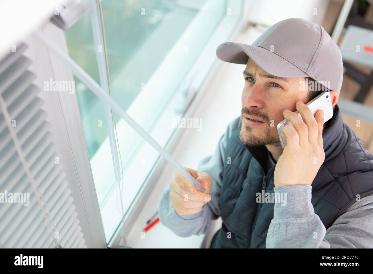 man installing cassette roller blinds on windows Stock Photo - Alamy