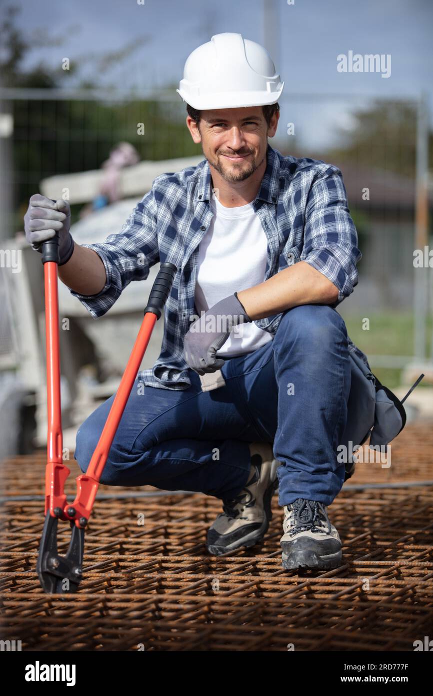 builder cuts rebars with bolt croppers on building site Stock Photo - Alamy