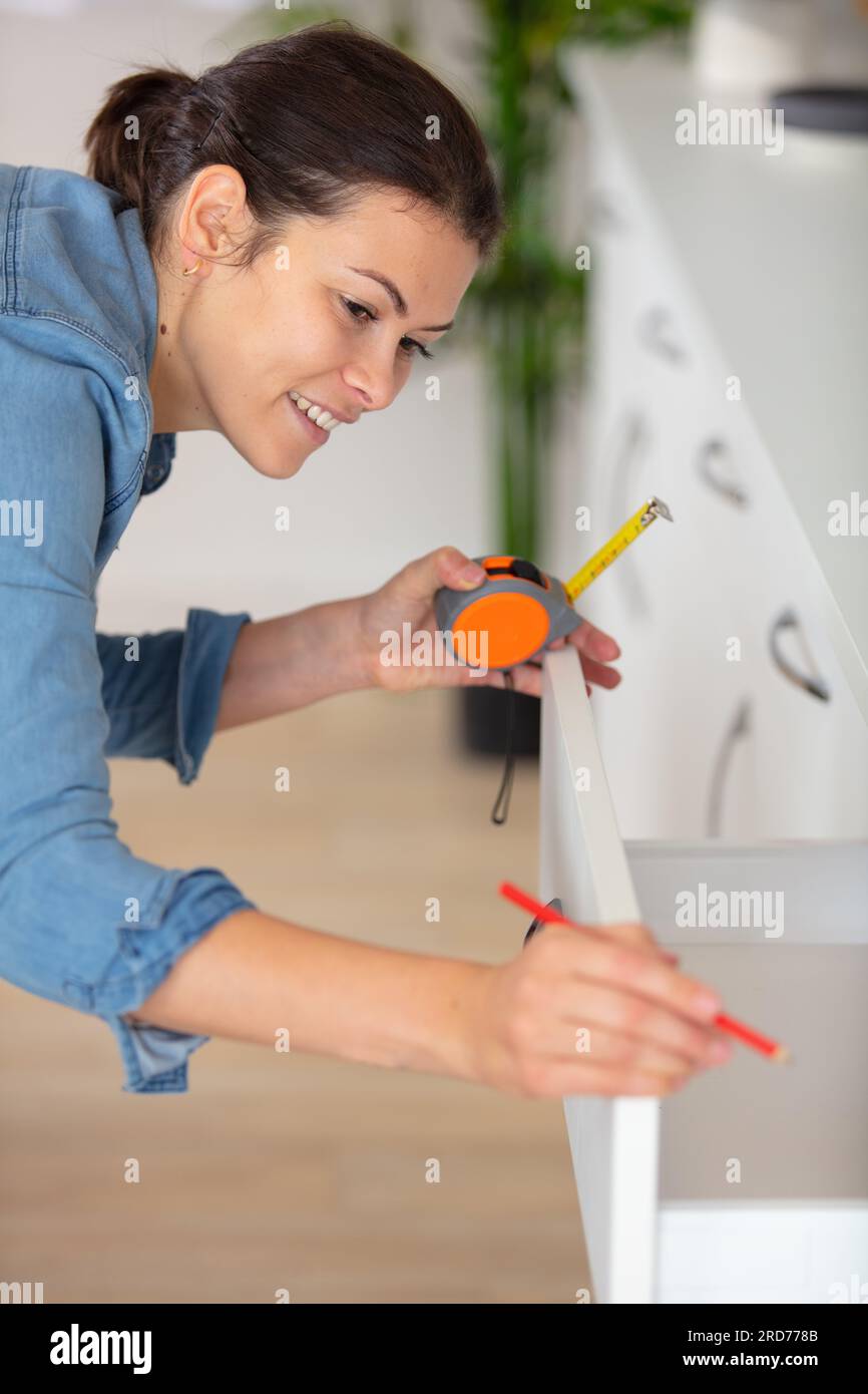young woman taking measures in her kitchen Stock Photo - Alamy
