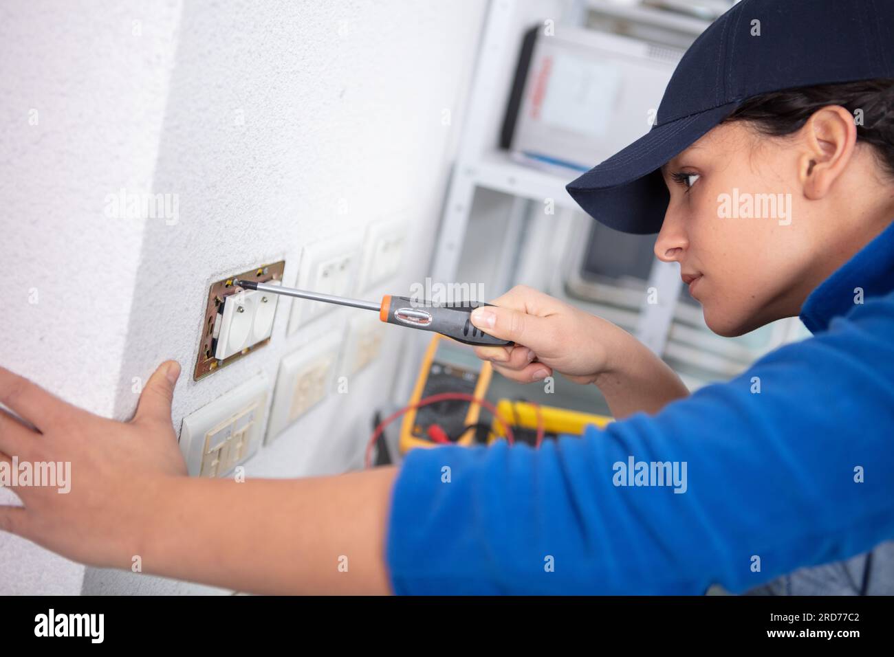 female electrician fixing socket to the wall Stock Photo - Alamy