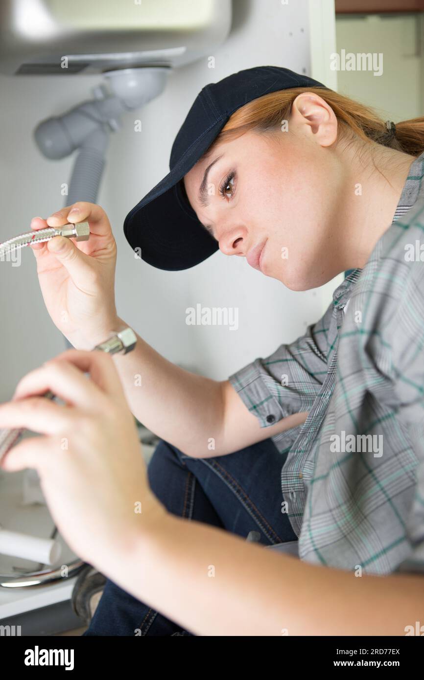 woman fixing the kitchen sink Stock Photo - Alamy