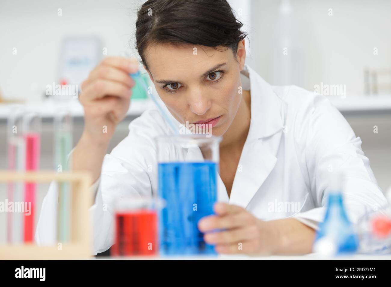 woman lab assistant with flasks with liquids Stock Photo - Alamy
