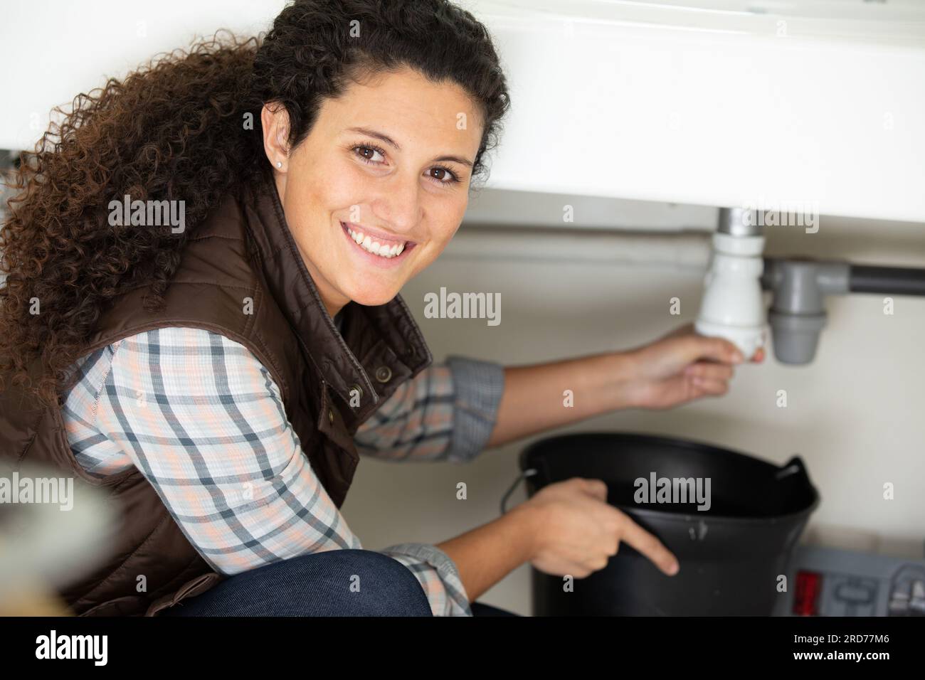 happy female plumber fixing sink Stock Photo - Alamy