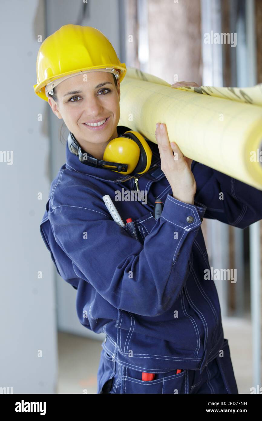 happy woman builder holding wallpaper Stock Photo - Alamy
