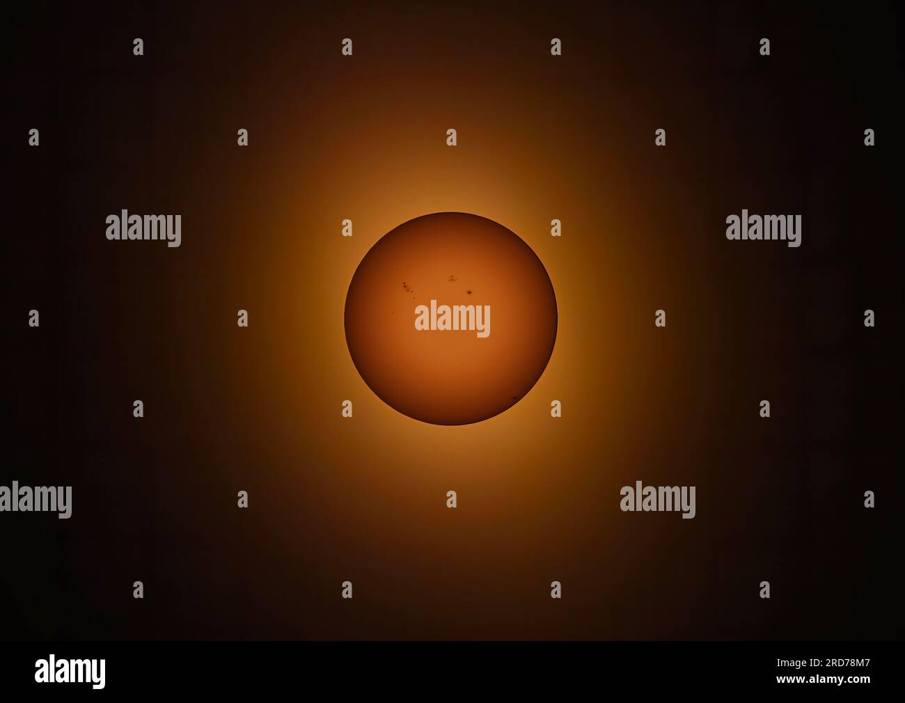 The orange coloured sun glowing with many sunspots using a homemade ...